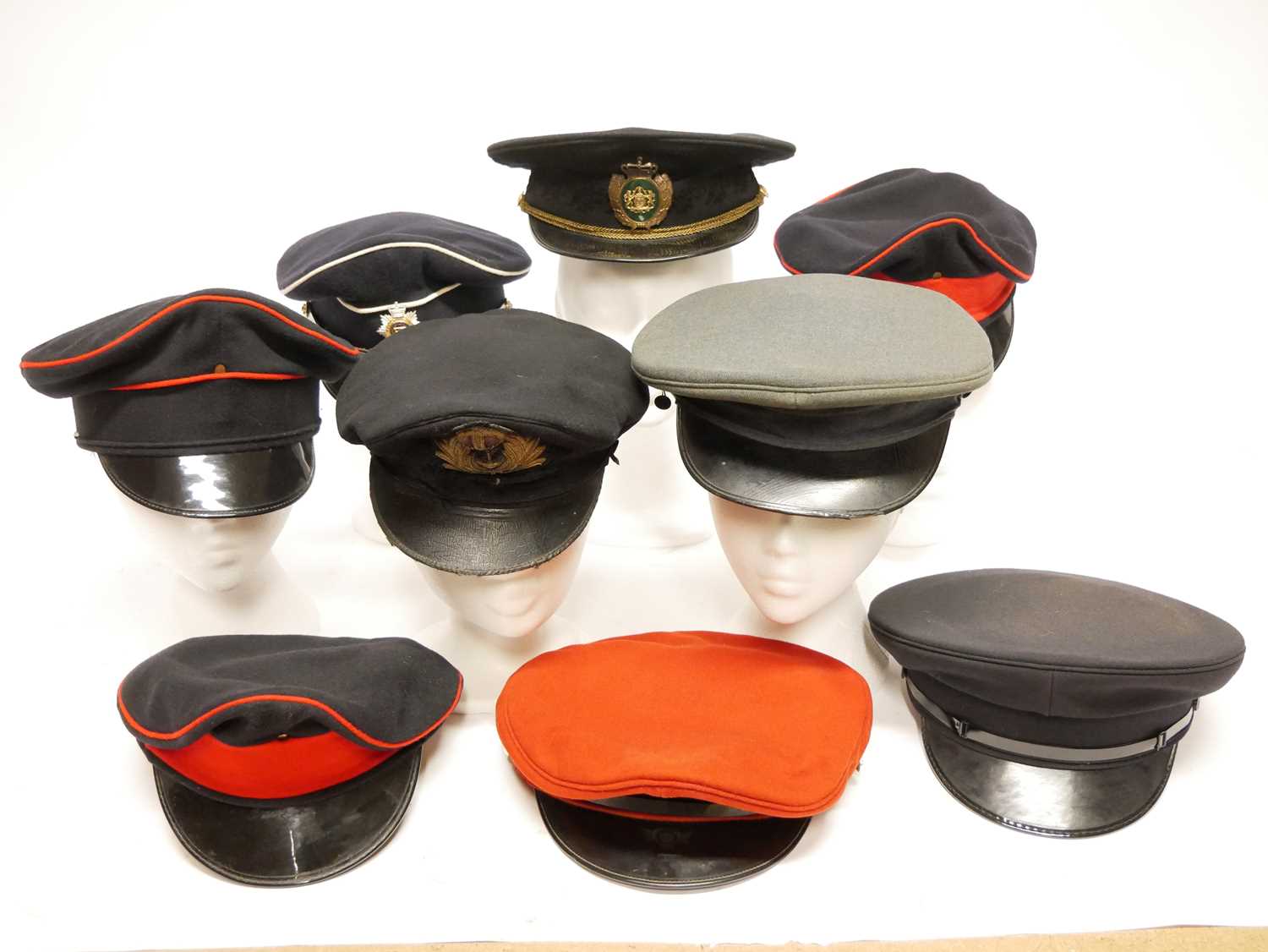 Lot 174 - Twenty one peaked caps, six with badges, the